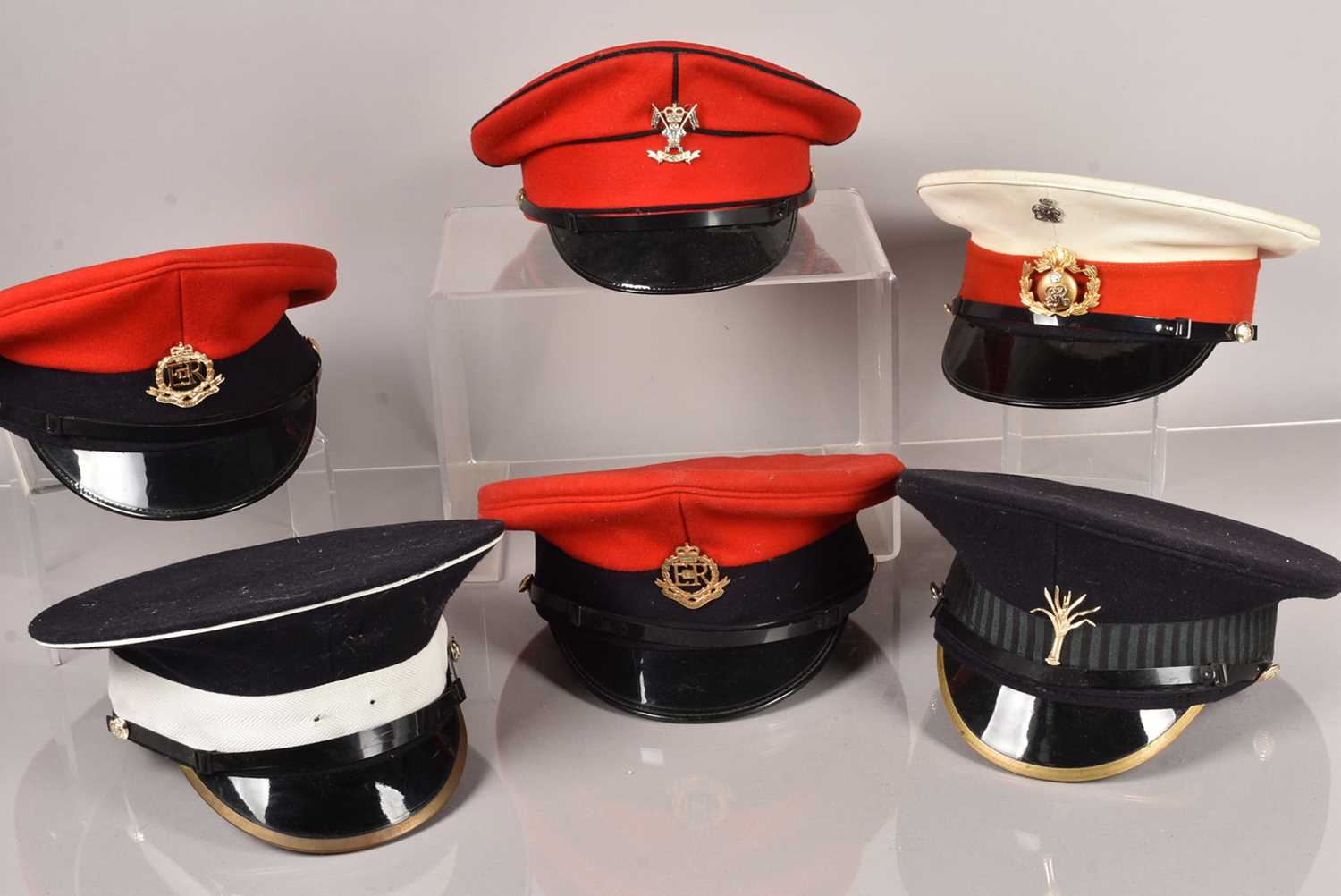 Lot 566 - A collection of Military peak caps,