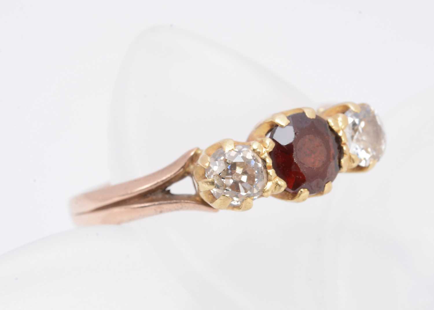 Lot 370 - An 18ct gold garnet and diamond three stone