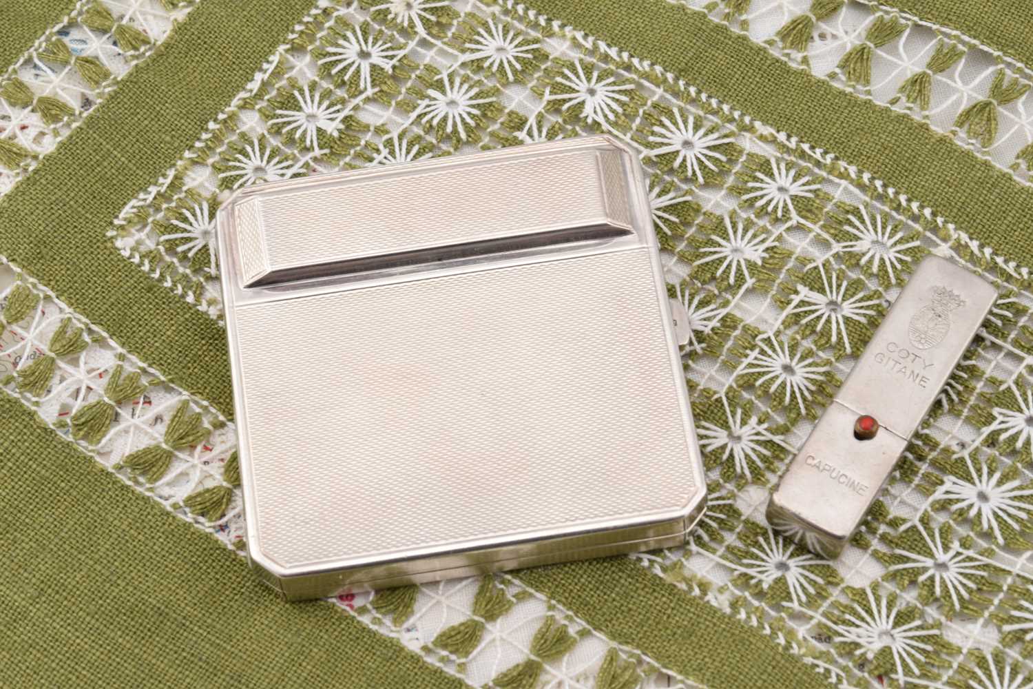 Lot 299 - A square engine turned decorated compact duo,